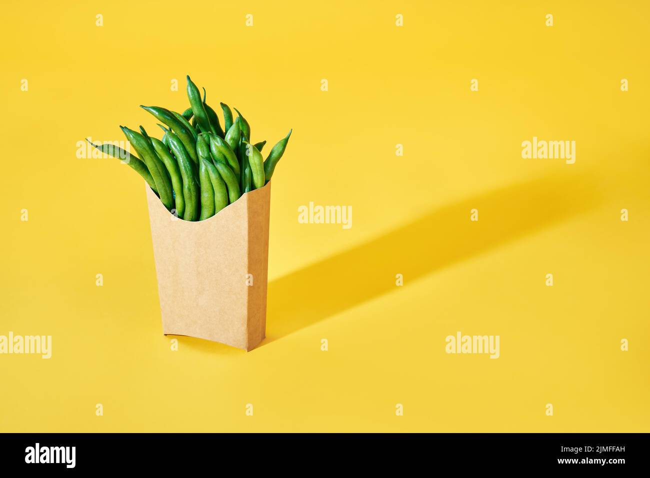 Fresh green beans in fast food paper box on bright yellow background ...