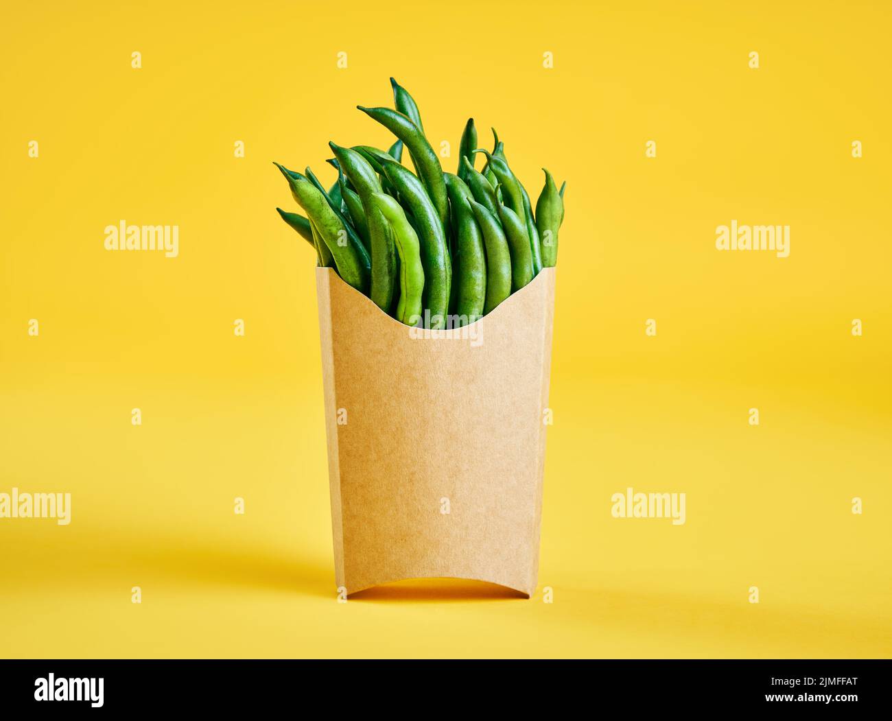 Fresh green beans in fast food paper box on bright yellow background ...