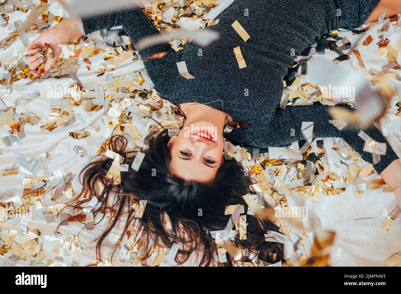 party free alone brunette bed confetti relaxation Stock Photo - Alamy