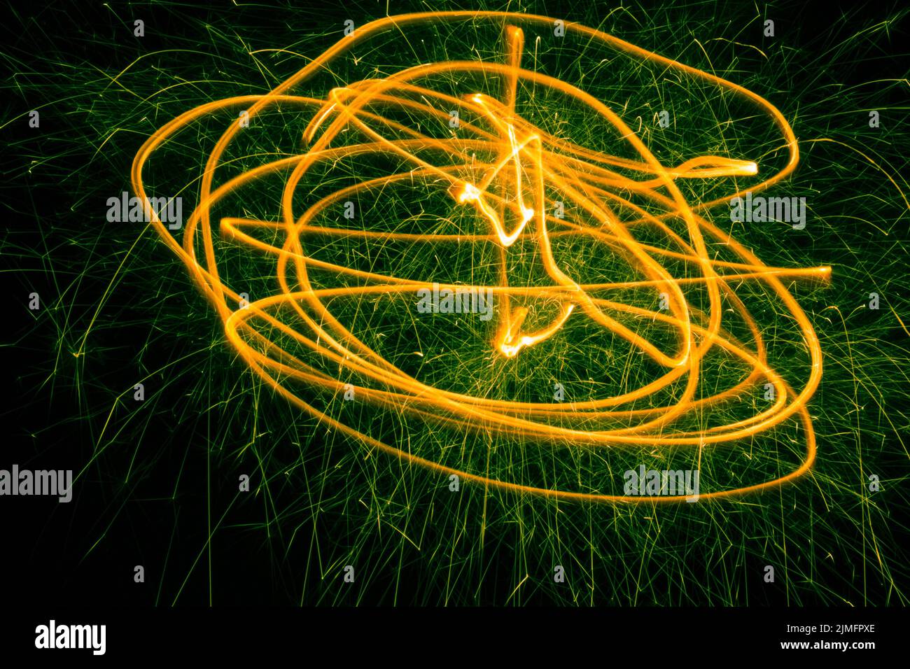 Sparks of holiday light fly on a black background. Drawing with light ...