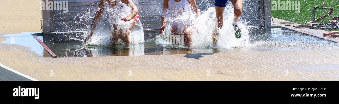Three high school girls getting very wet in the water pit of the ...