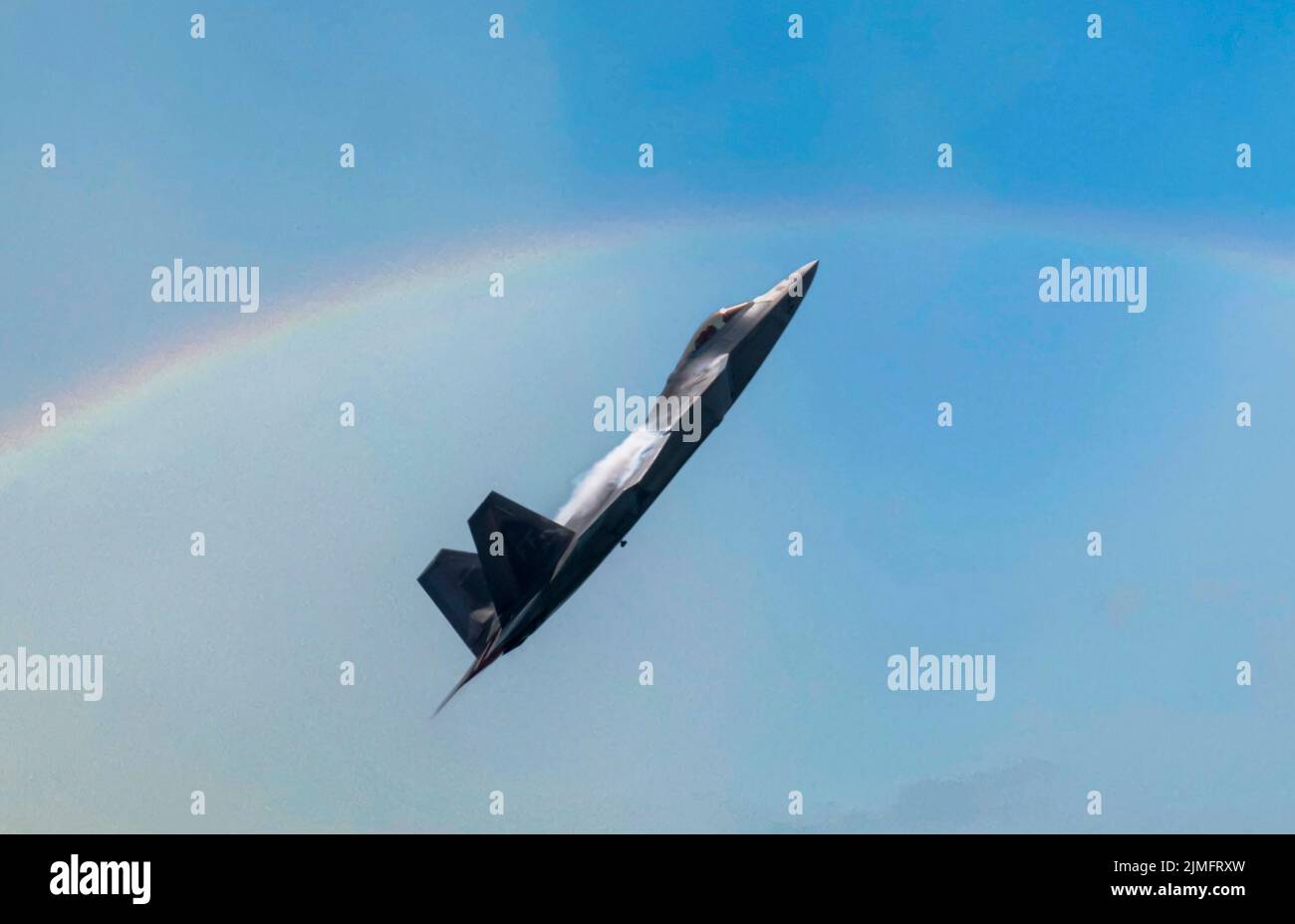 US Airforce F-22 Raptor climbing high into the sky with water vapor ...