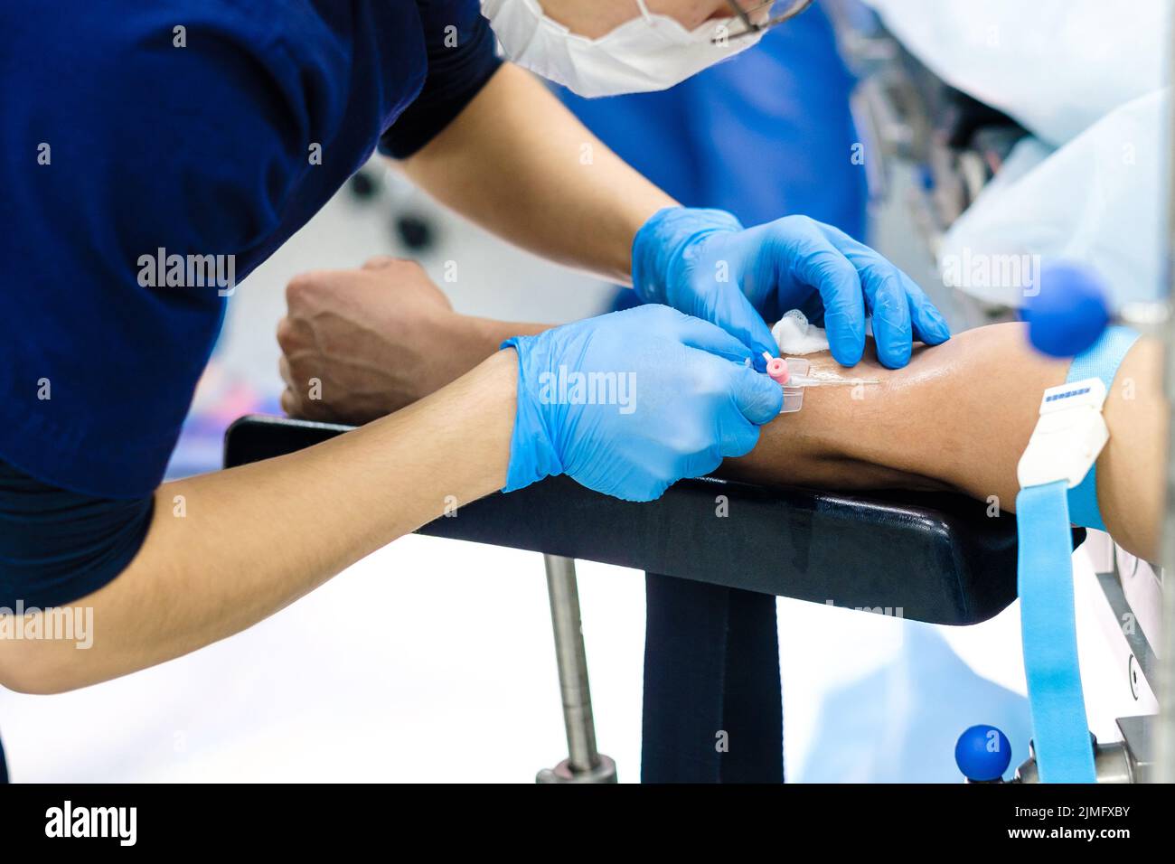 The doctor inserts a dropper needle into a vein in the patient's arm ...