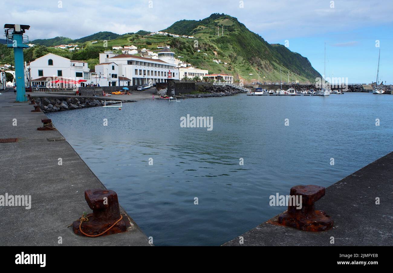 The town's waterfront and marina, rusty mooring cleats on the concrete ...