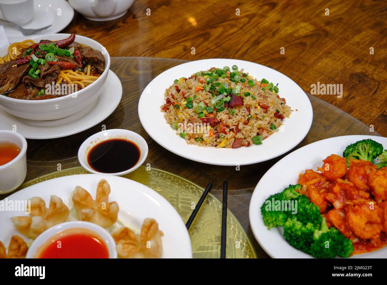 A selective focus shot of a table full of Chinese food in different ...