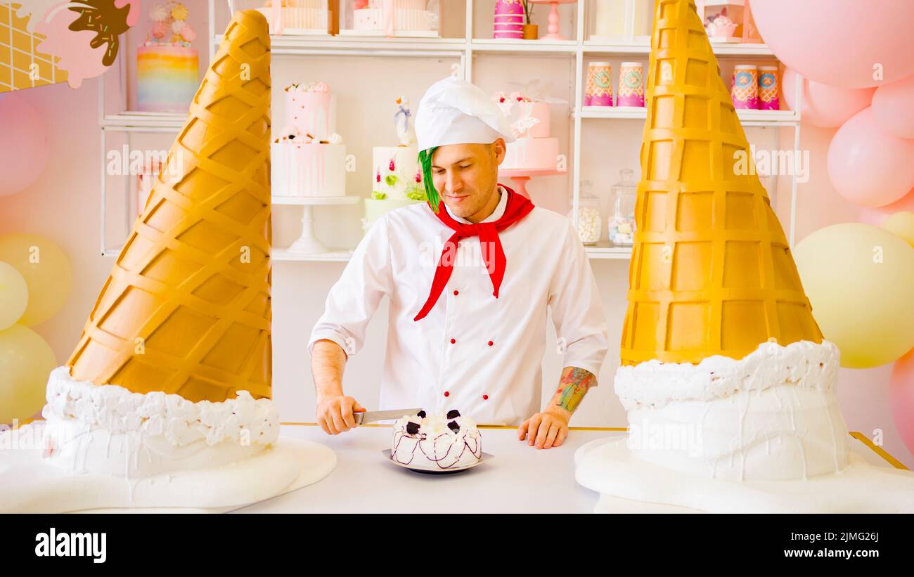 Chef cutting cake in confectionery. Content male confectioner cutting ...