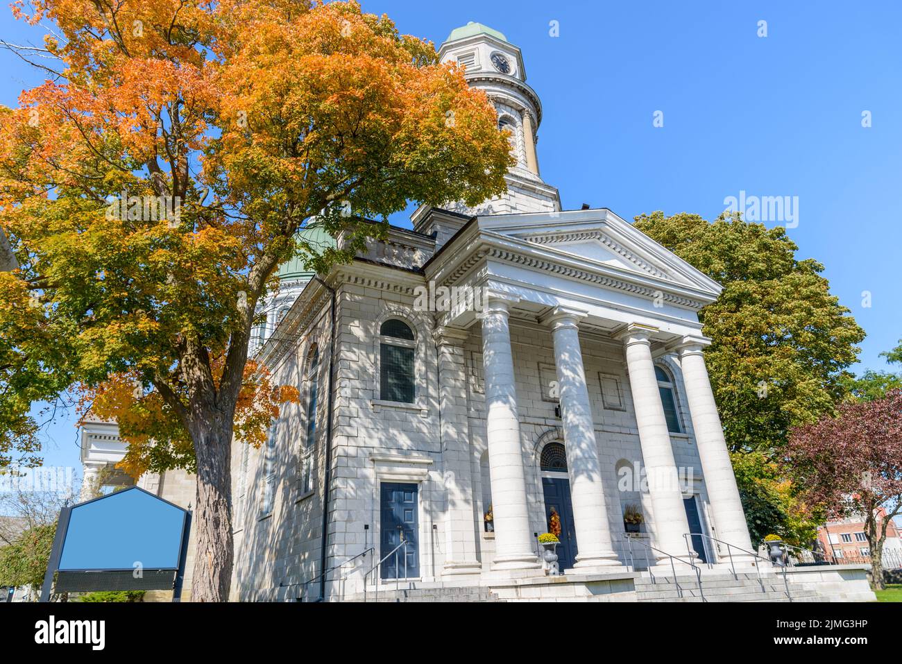 Autumnal maple tree by a traditional white stone church with front ...