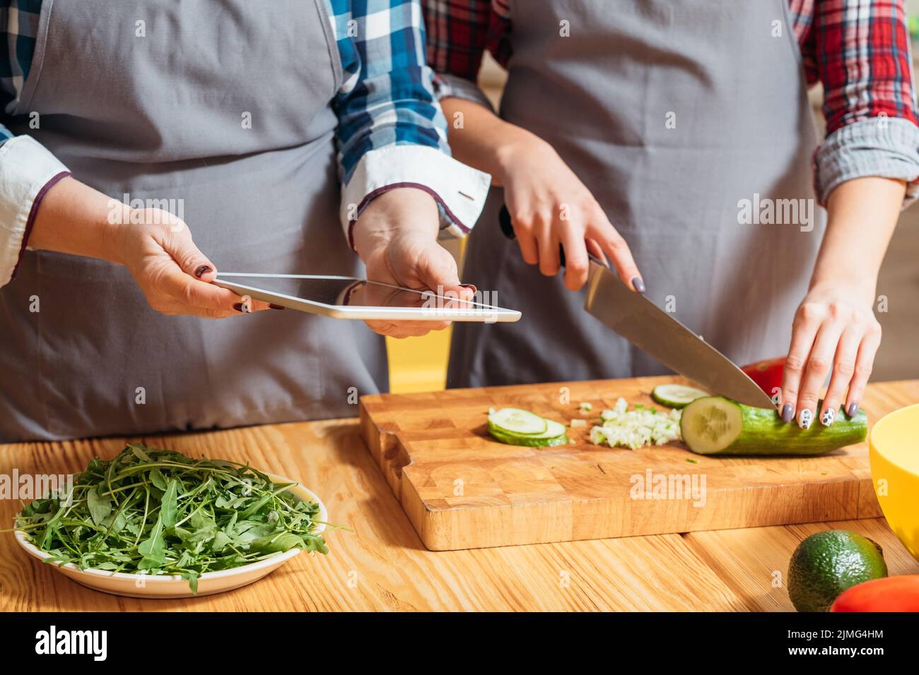 online recipe tablet women chopping veggies salad Stock Photo - Alamy