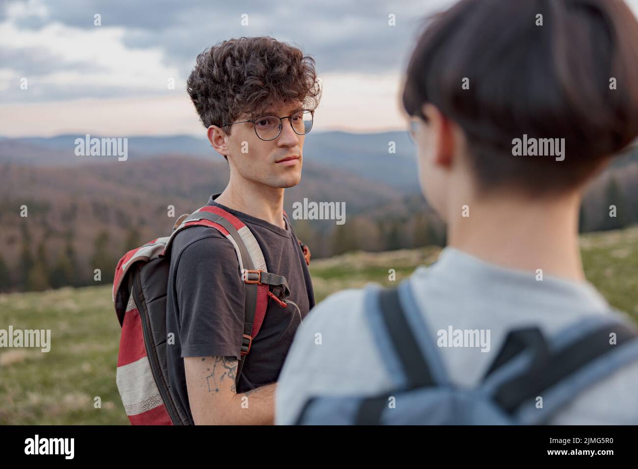 Portrait of man hiker talking with female friend or girlfriend on mount ...