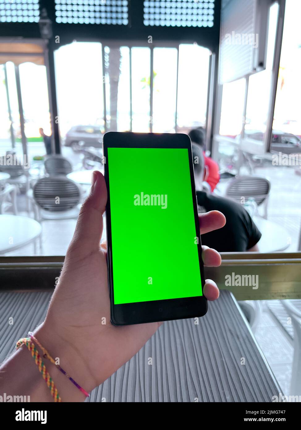 Male hand holds an unbranded smartphone with blank green screen Stock ...