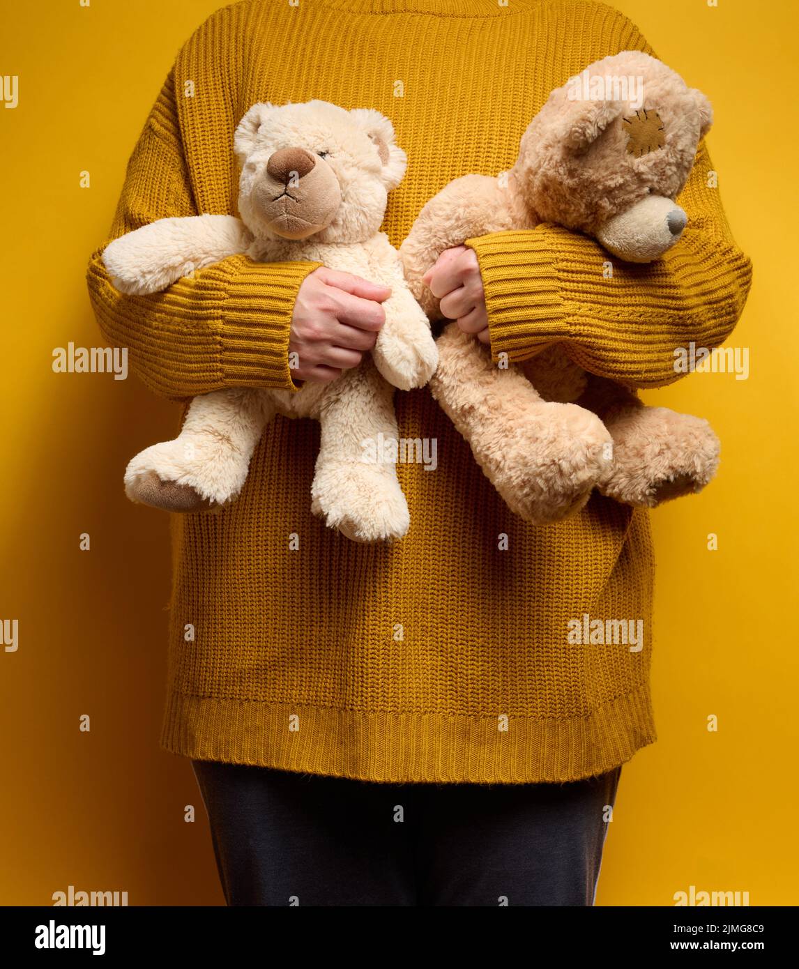 Woman in orange knitted sweater hugs cute brown teddy bear Stock Photo ...