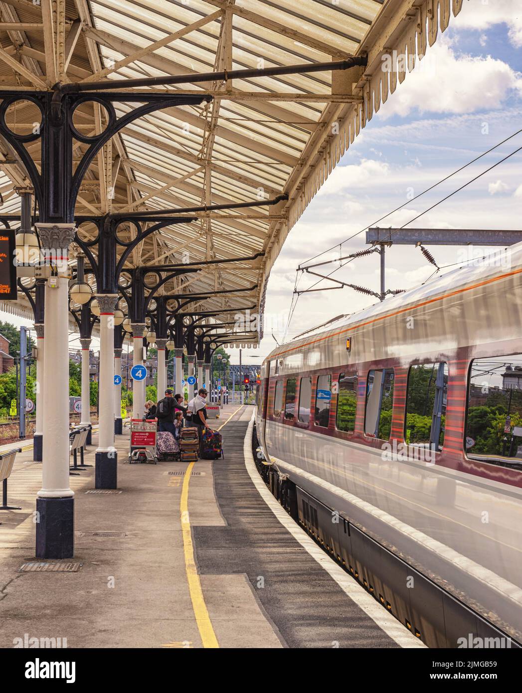 A railway carriage rests beside a platform while preparing to depart. A ...