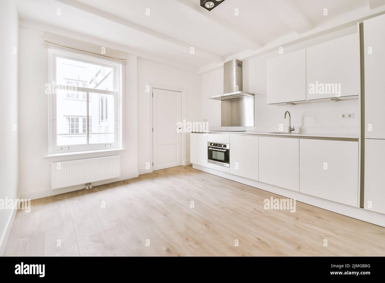 Interior of empty white kitchen with windows and wooden parquet floor ...