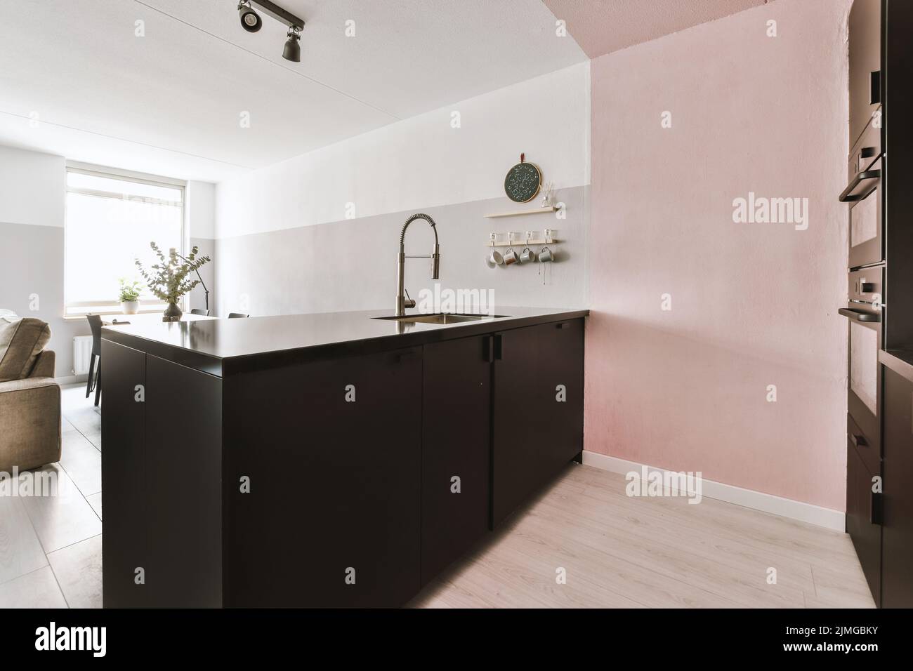 Simple interior of light living room with gray sofa in front of TV and ...