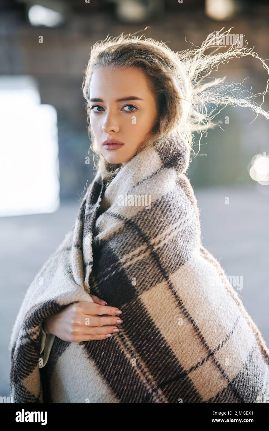 Beautiful young woman portrait wrapped in wool blanket looking to ...