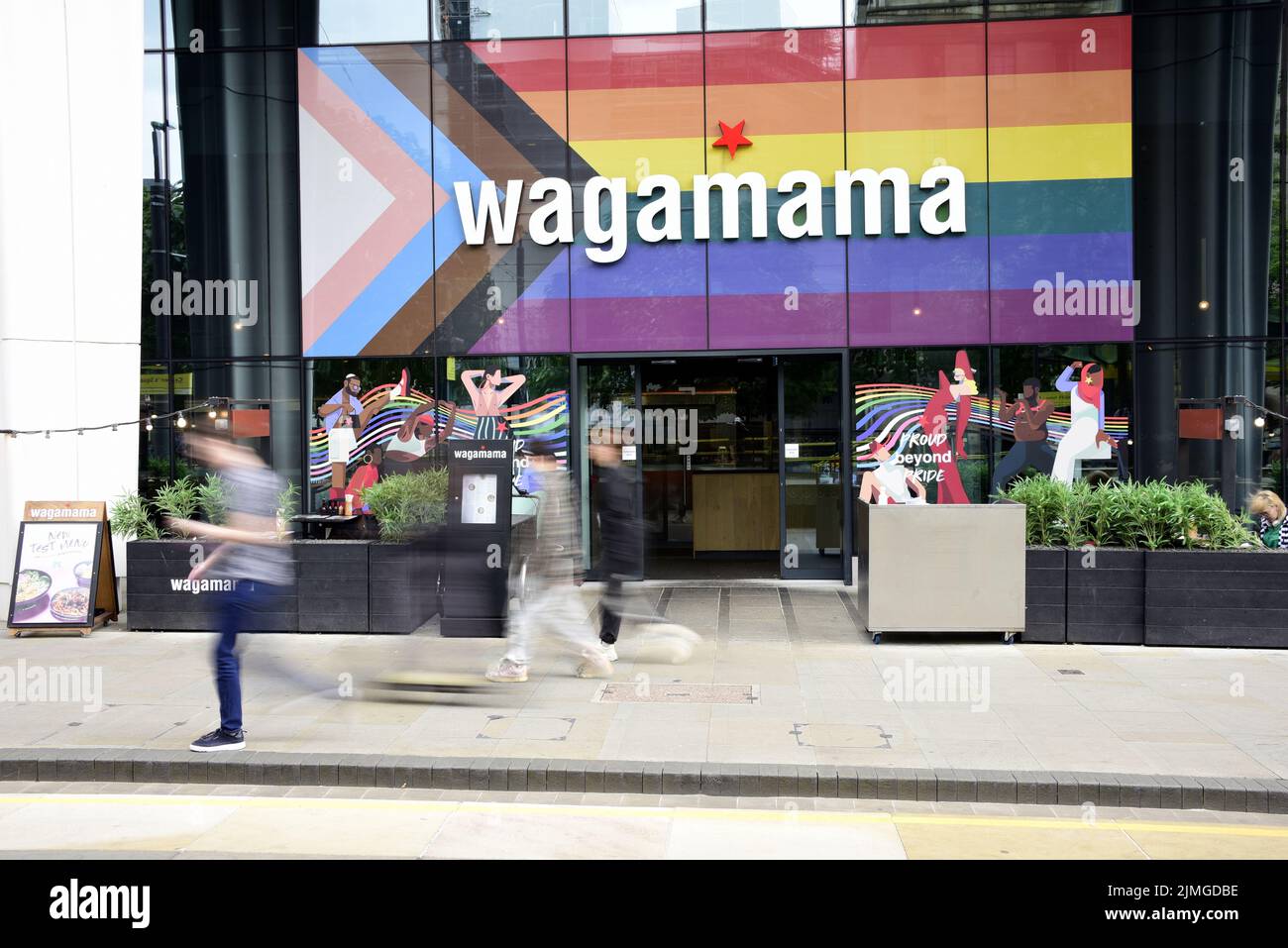 People walk past Wagamama restaurant, St Peter's Square, Manchester, UK ...