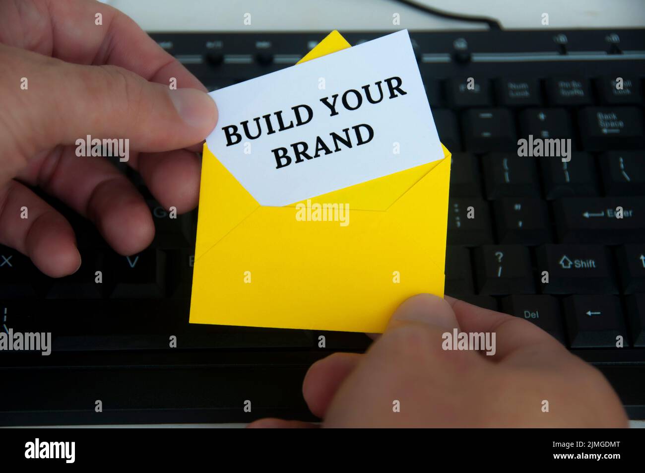 Hand holding with notepad in yellow envelope with text - Build your ...