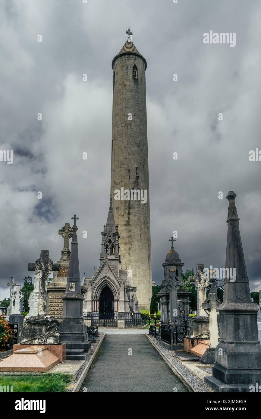 Ancient graves and tombstones in Glasnevin Cemetery with Round Tower ...