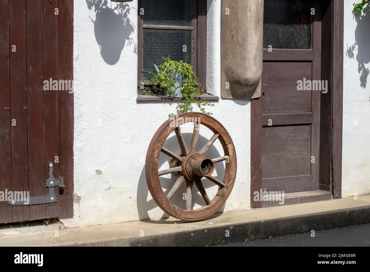 Antique vintage wooden carriage wheel hanging on the wall. Home rustic ...