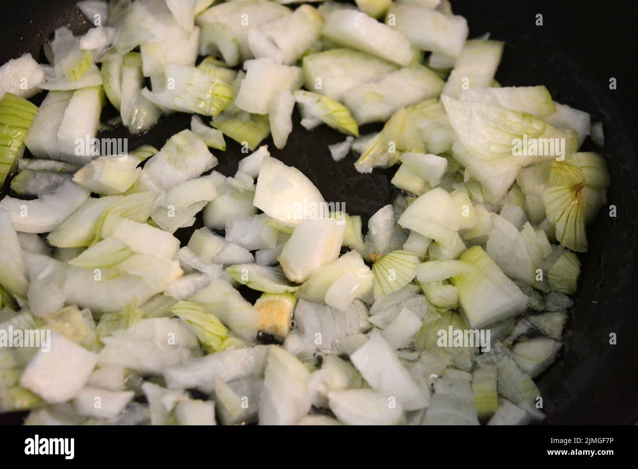 Cooking healthy food, onion is cut into cubes and fried in a black ...
