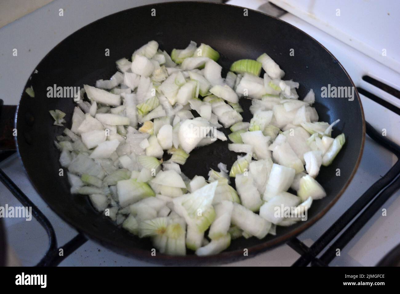 Cooking healthy food, onion is cut into cubes and fried in a black ...