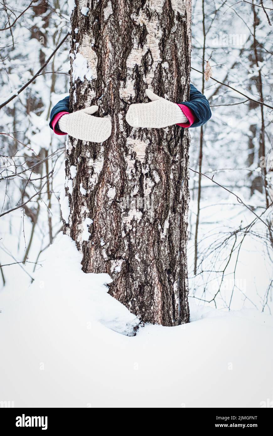 Hugging trees in winter forest, unity with nature Stock Photo - Alamy