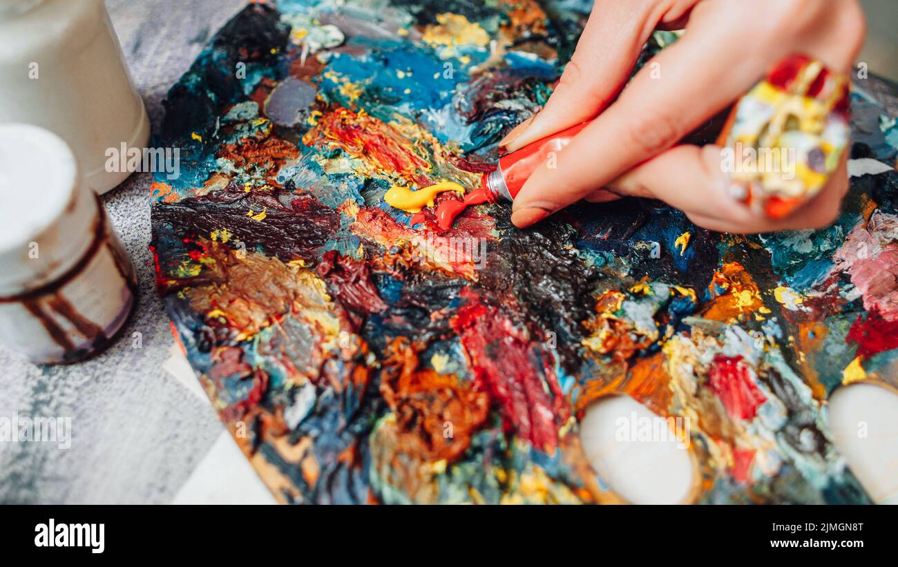artist squeezing paint multicolored palette Stock Photo - Alamy