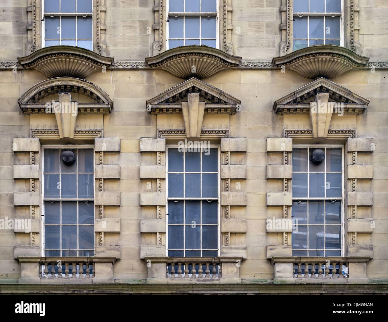 Three Art Deco window, detail of a stone builing with typical Art deco ...