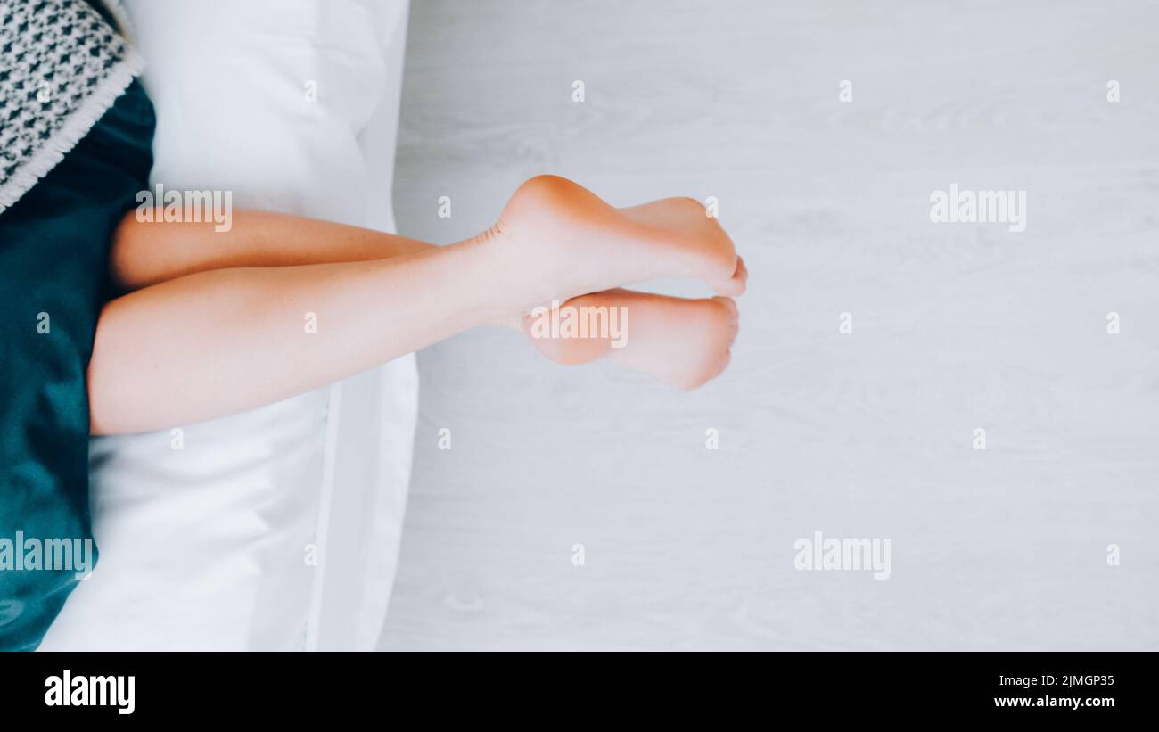 Body care and wellness. Cropped top view of barefoot woman in bed ...