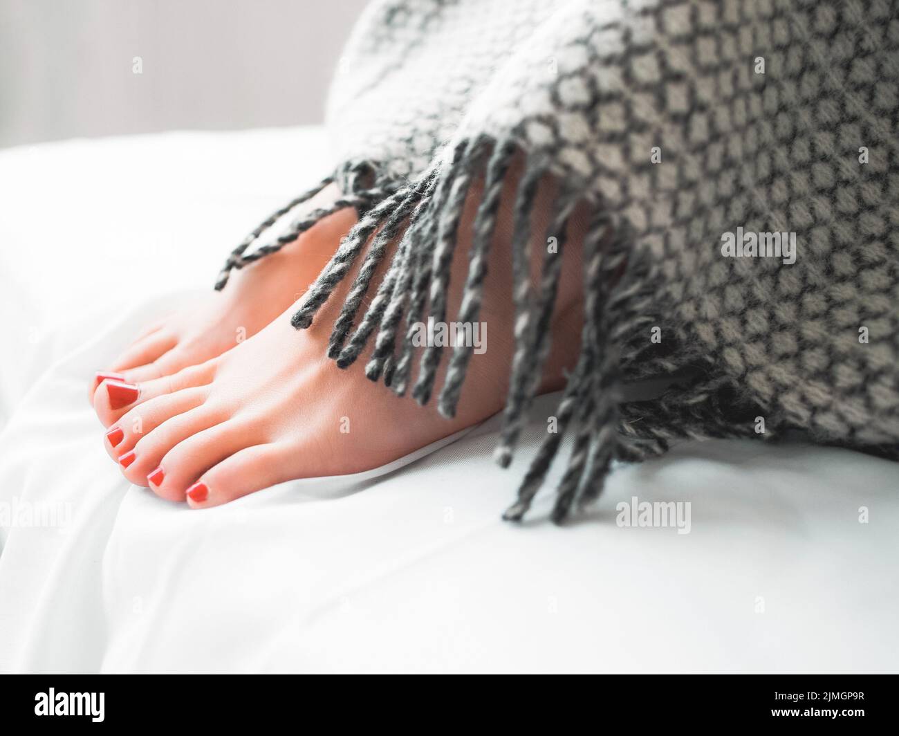 foot hygiene barefoot woman bed hiding feet Stock Photo - Alamy