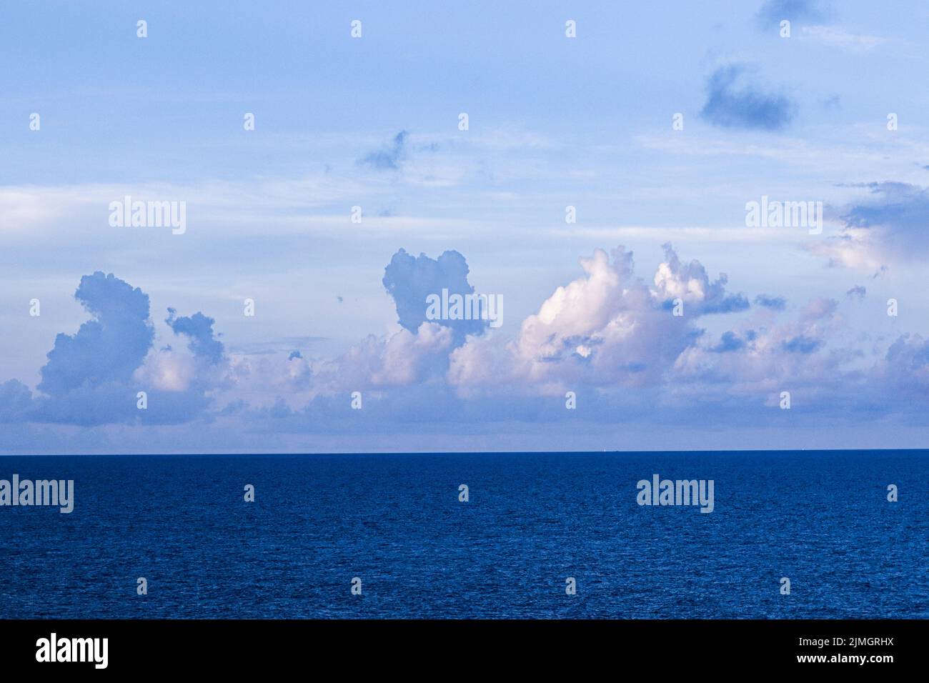 A breathtaking view of cloudy sky and blue ocean water merging into the ...