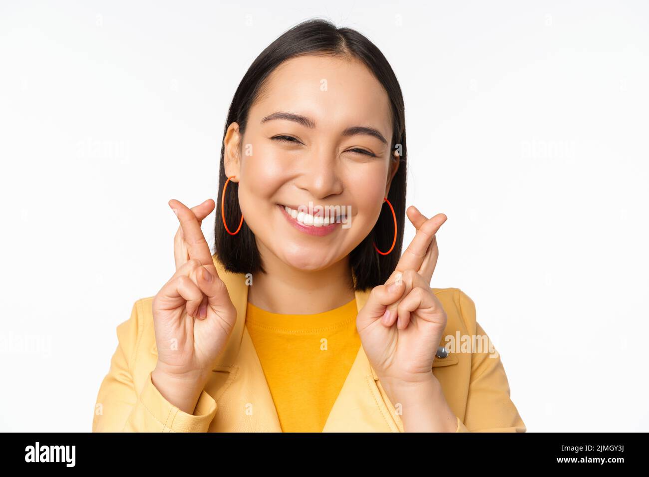 Close up portrait of hopeful asian girl wishing, cross fingers for good ...