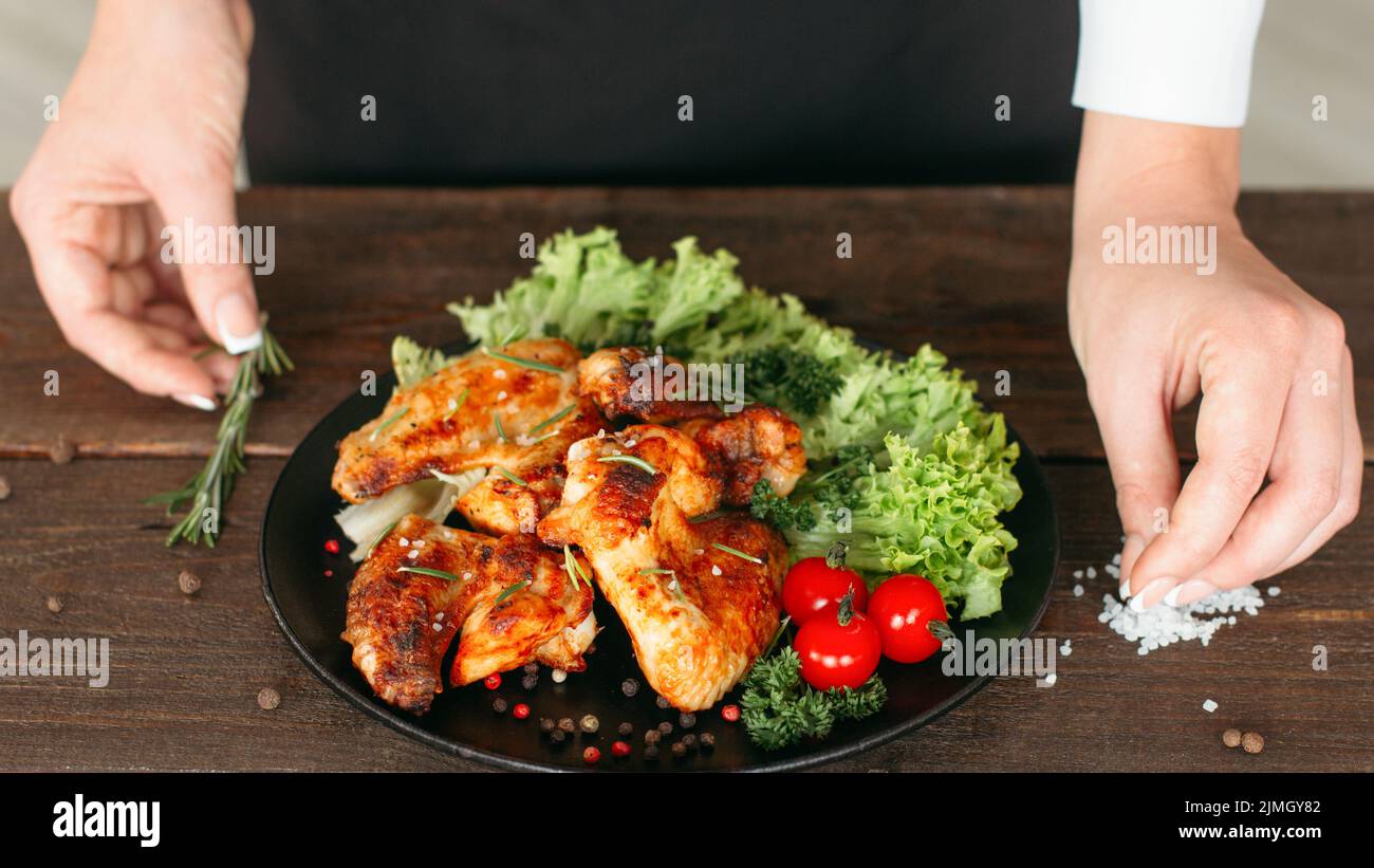 food cooking styling grilled chicken wing add salt Stock Photo - Alamy
