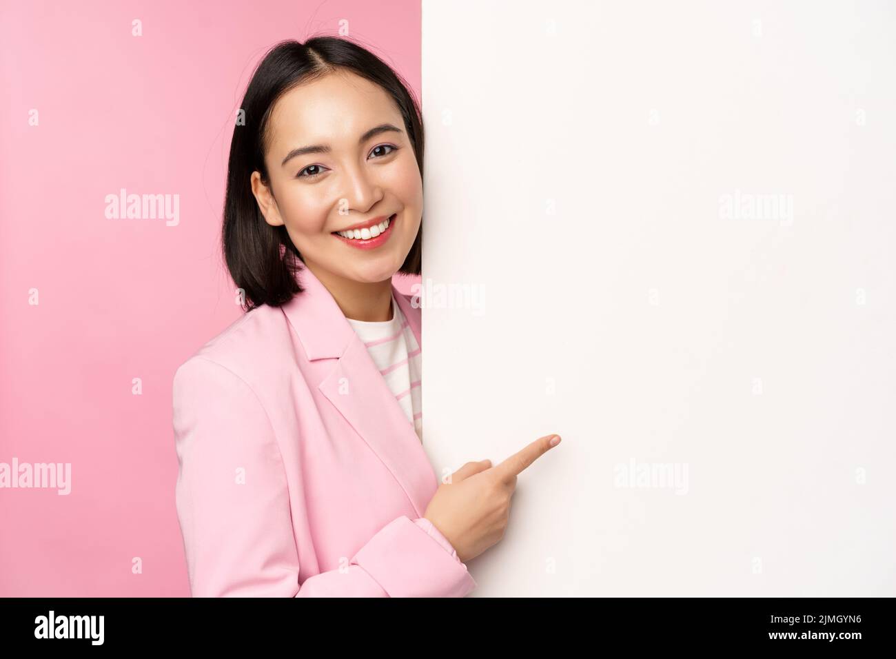 Image of asian female entrepreneur in suit, pointing finger at board ...