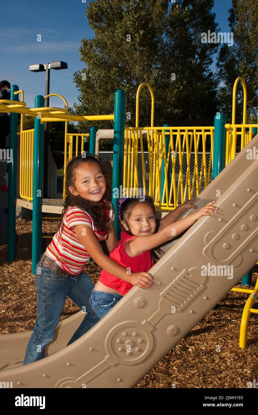 Two Native American children play on a slide connected to other ...