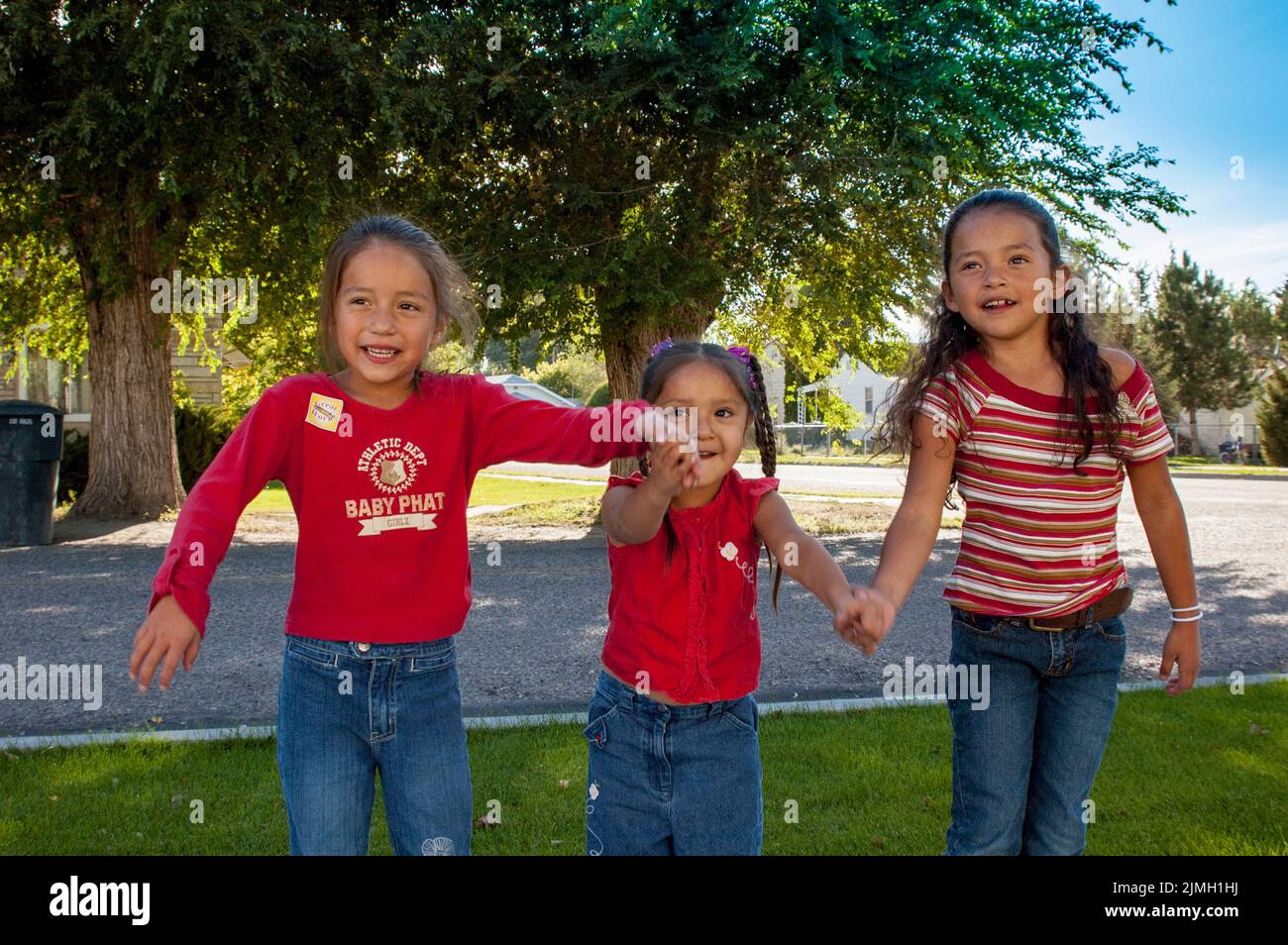 Three elementary age girls, friends and cousins, hold hands during ...
