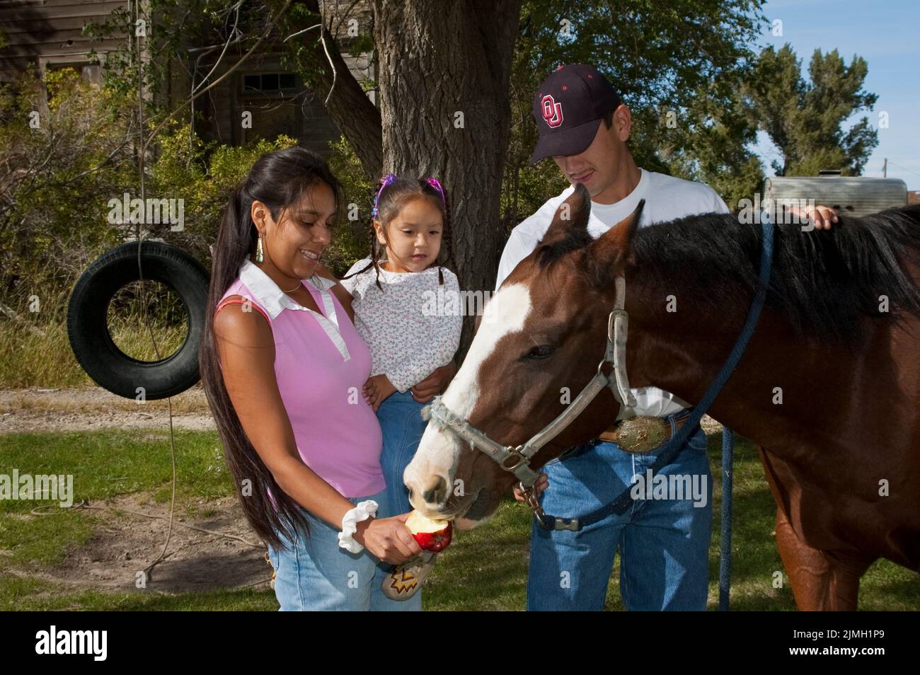 Native American family of feed an apple to their pet horse, Fort Hall ...