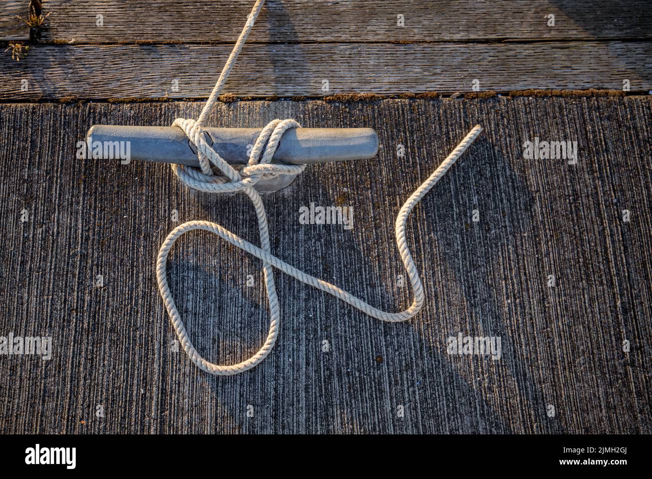 Boats rope tied to anchor on the pier Stock Photo - Alamy
