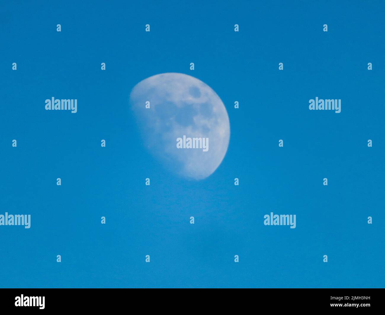 An interesting view of the Moon half hidden in the clear blue sky Stock ...