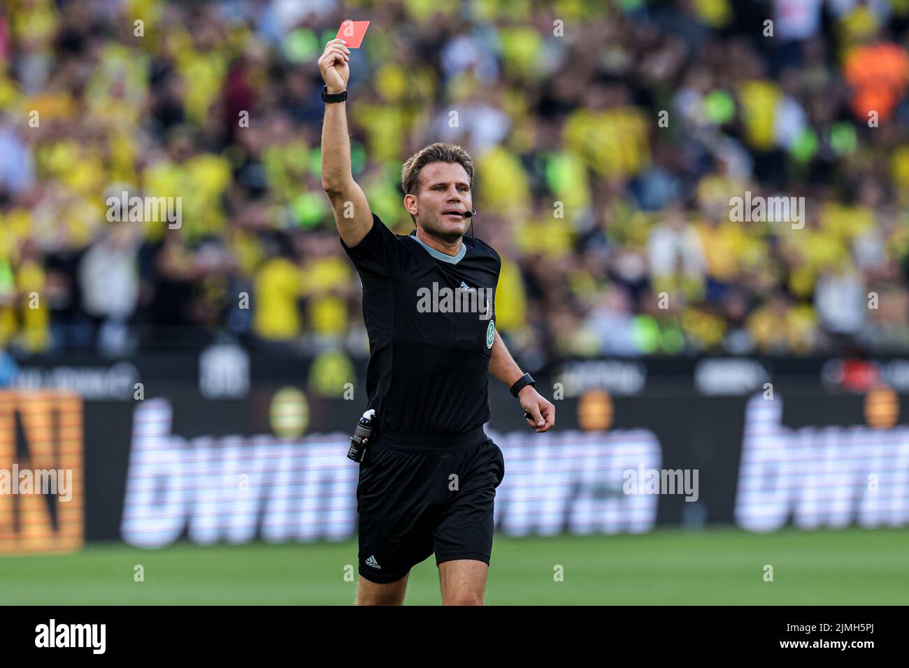 DORTMUND, GERMANY - AUGUST 6: referee Felix Brych shows a yellow card ...