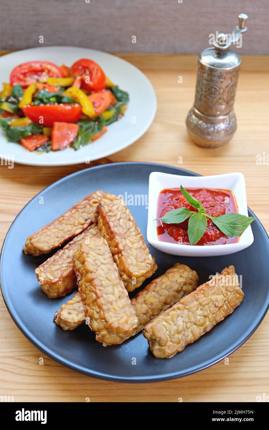 Pan fried Tempeh wih homemade marinara sauce with blurry vegetables ...