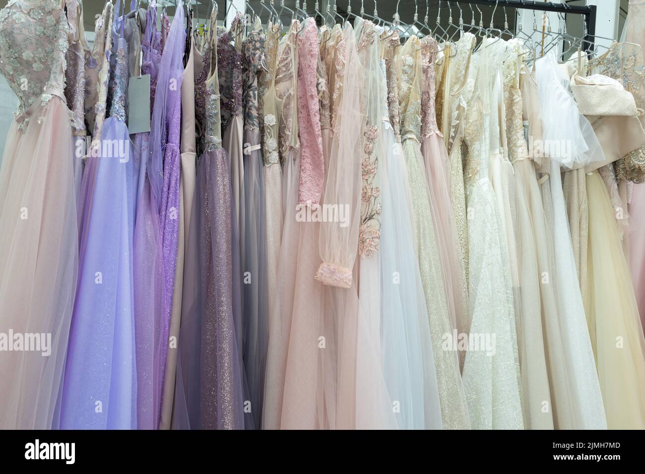 Many different evening and wedding dresses close-up on a hanger in a ...