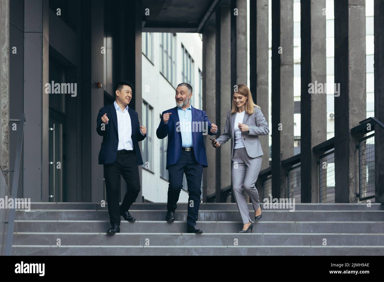 diverse business team, man and woman walking together outside office ...