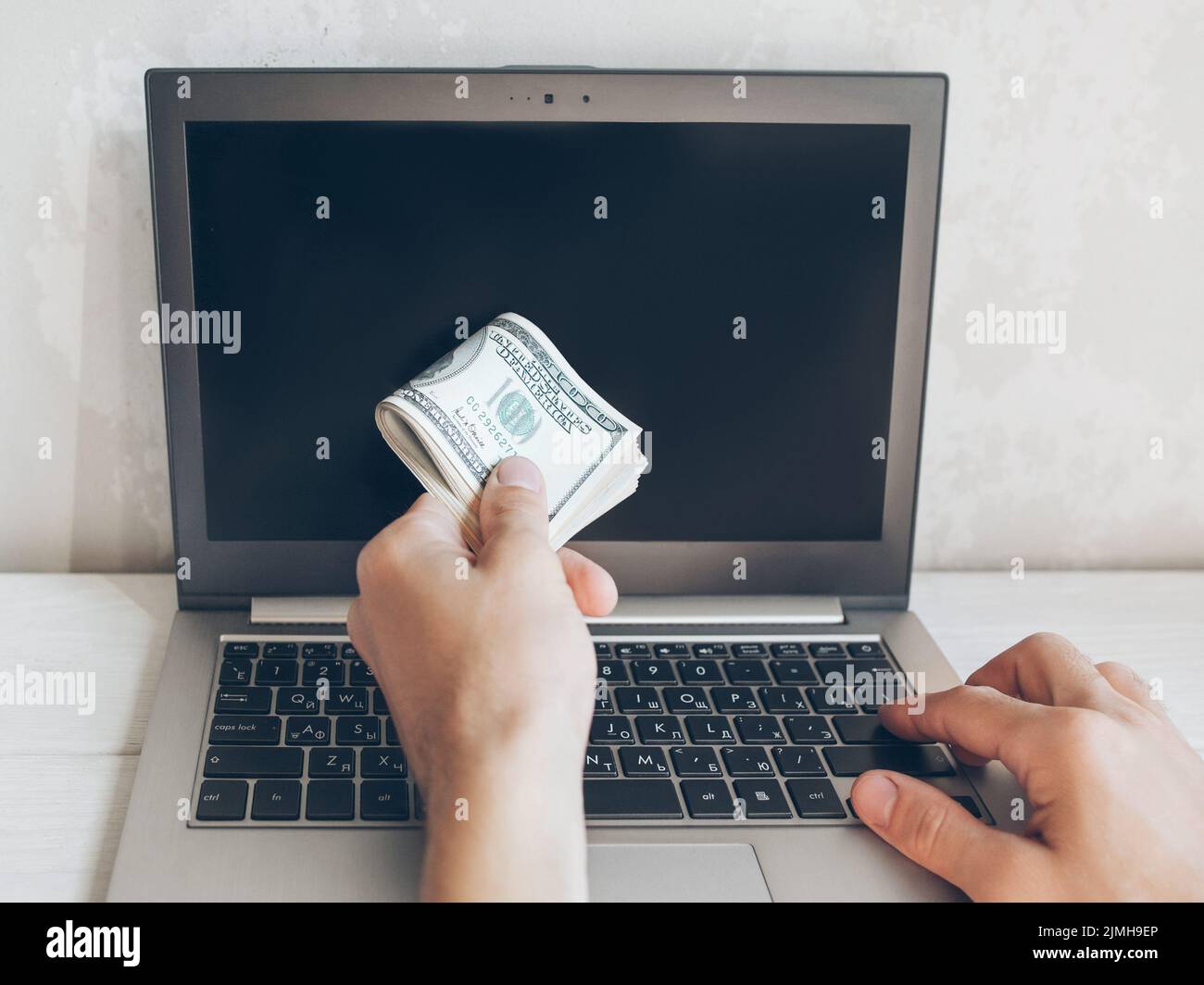 online banking hundred dollar bills laptop hand Stock Photo - Alamy