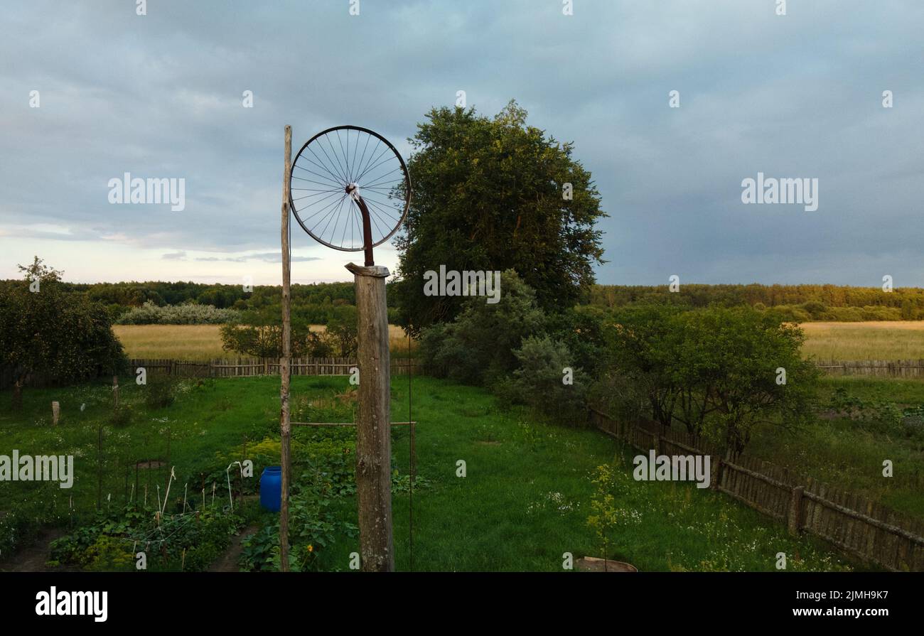 Old village well. Lifting mechanism from a bicycle wheel. Against the ...