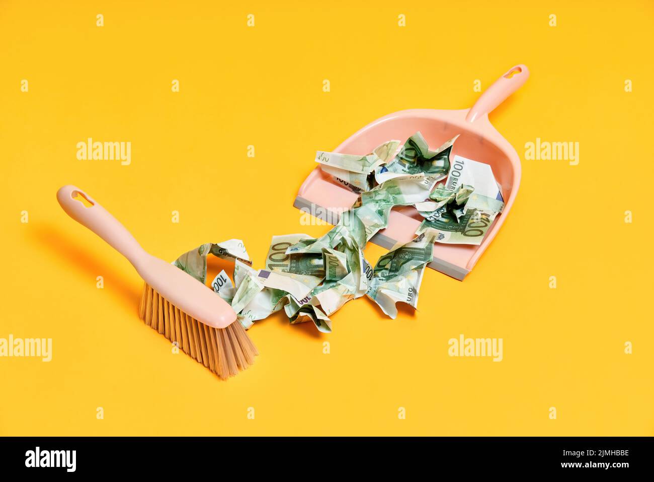 Creative layout with dustpan, hand brooms and crumpled money dollar ...