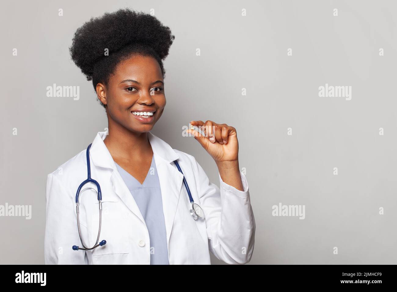 Positive doctor woman showing pill tablet on white background Stock ...