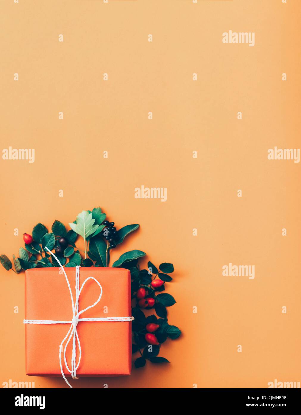 gift delivery orange gift box peach background Stock Photo - Alamy