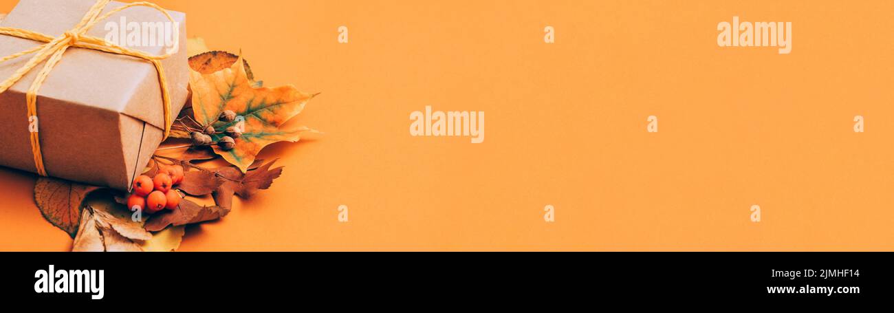 present beige gift box foliage orange background Stock Photo - Alamy