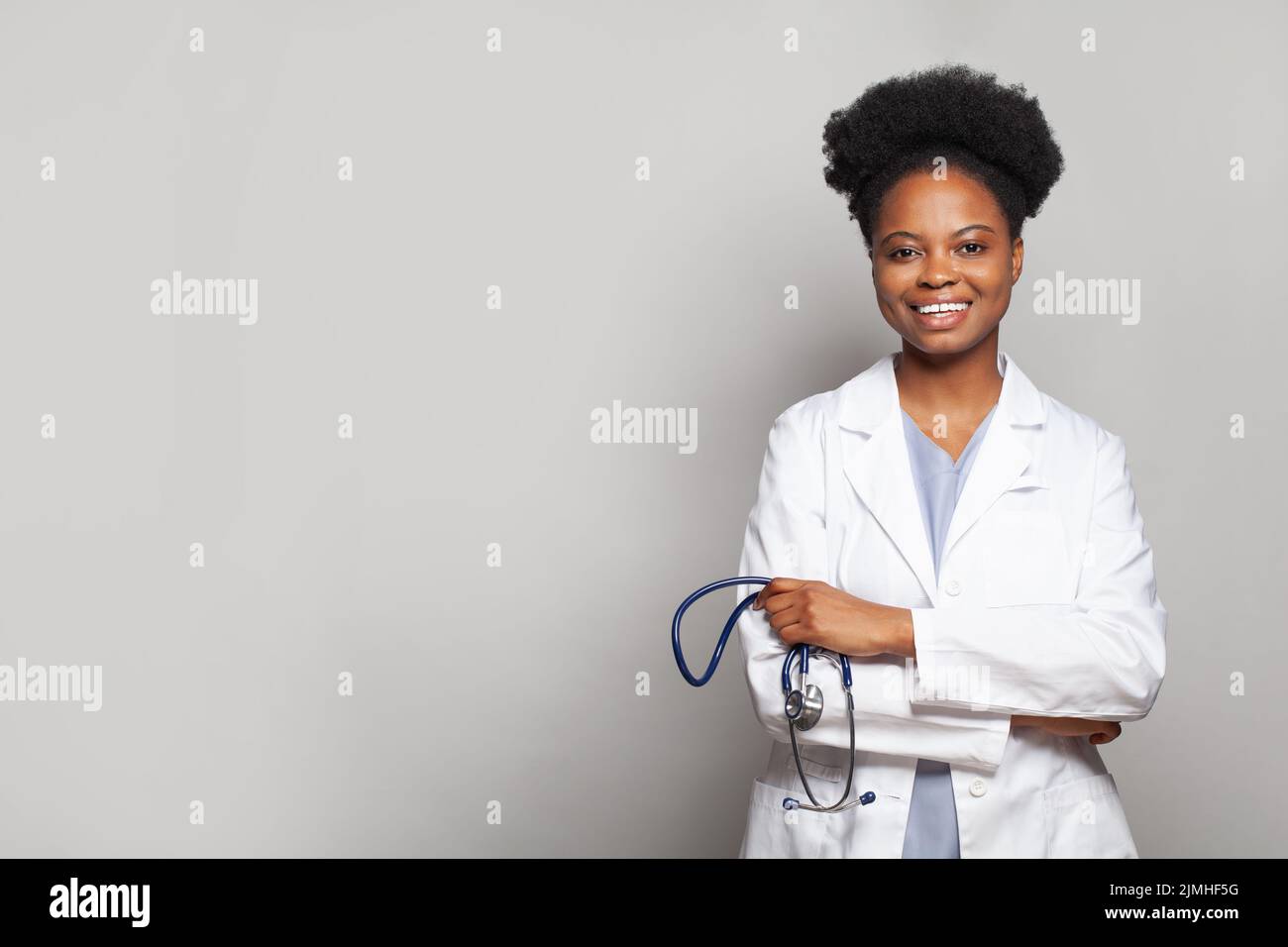 Portrait of happy medical intern doctor standing on white background ...